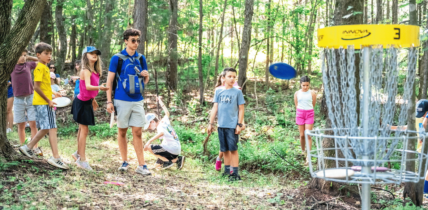 Summer camper throws a disc at Anne Springs Close Greenway’s disc golf ...